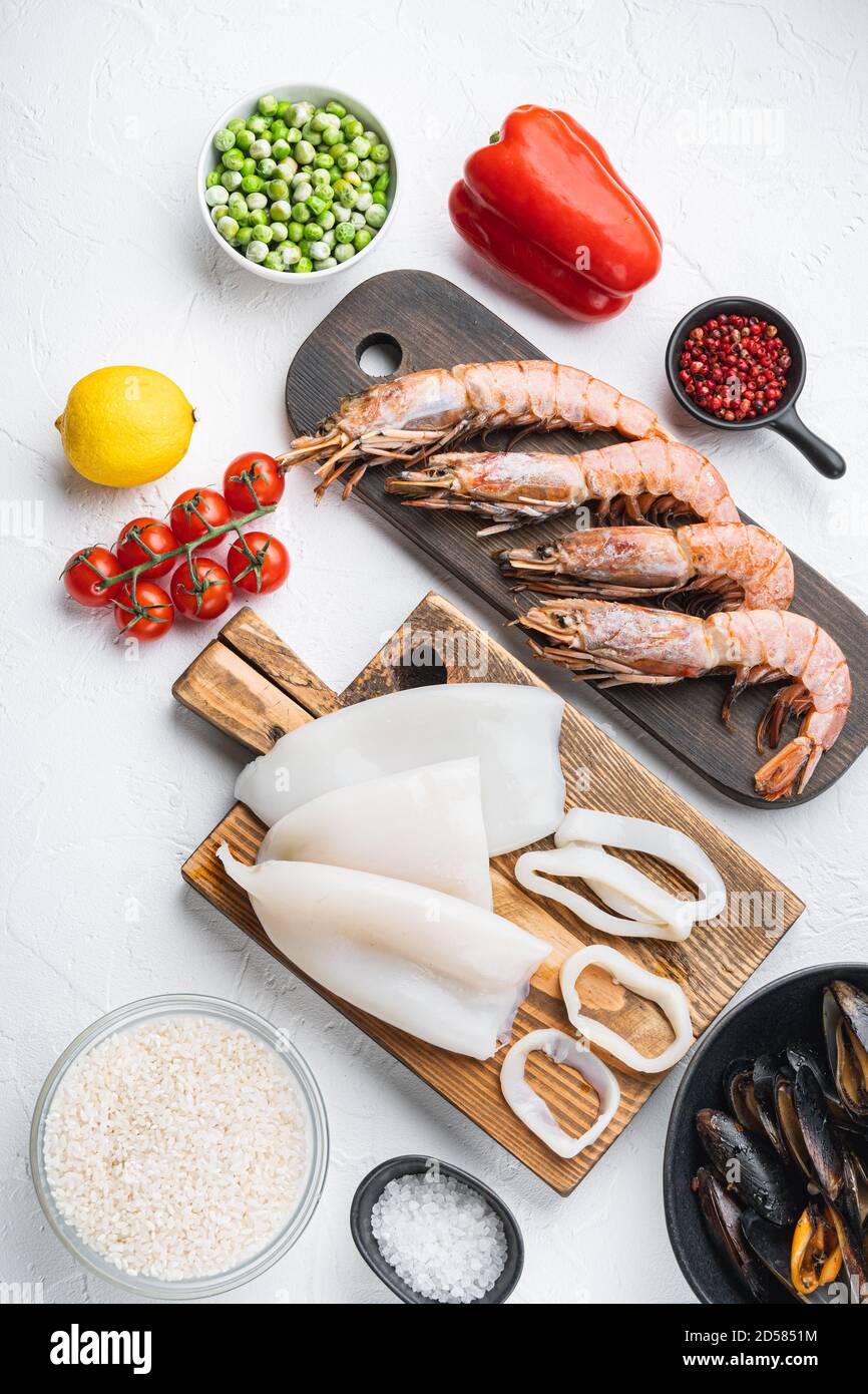 Fresh seafood assortment for paella on white textured background, flat ...