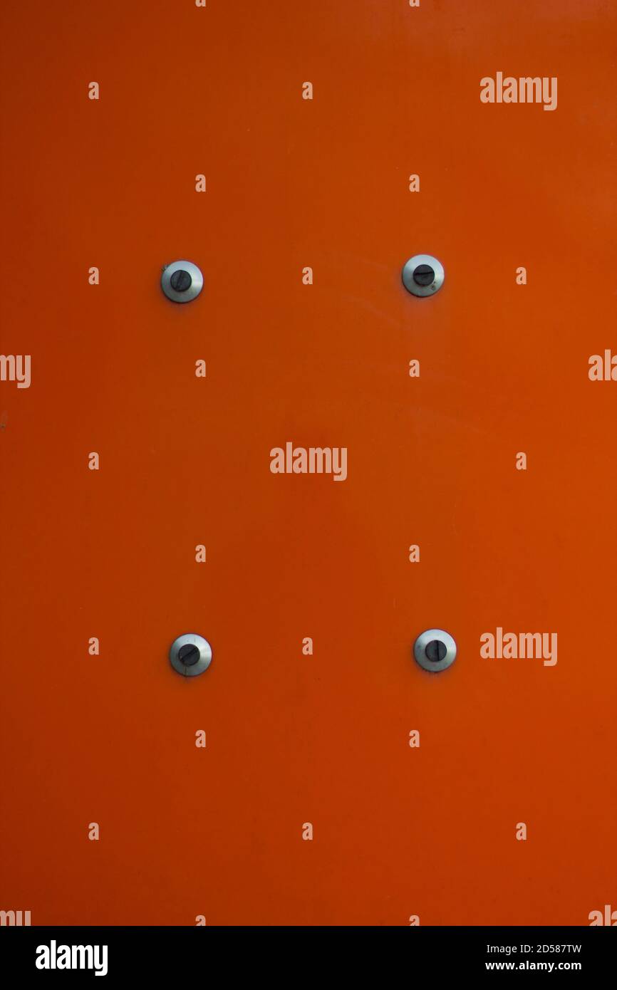 orange sign with four screws Stock Photo - Alamy