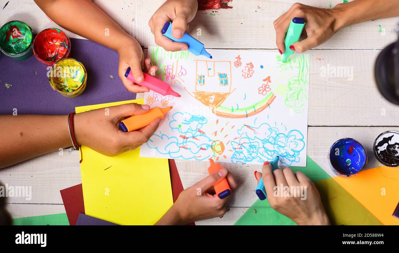 Art and idea concept. Hands hold colorful markers and draw kids ...