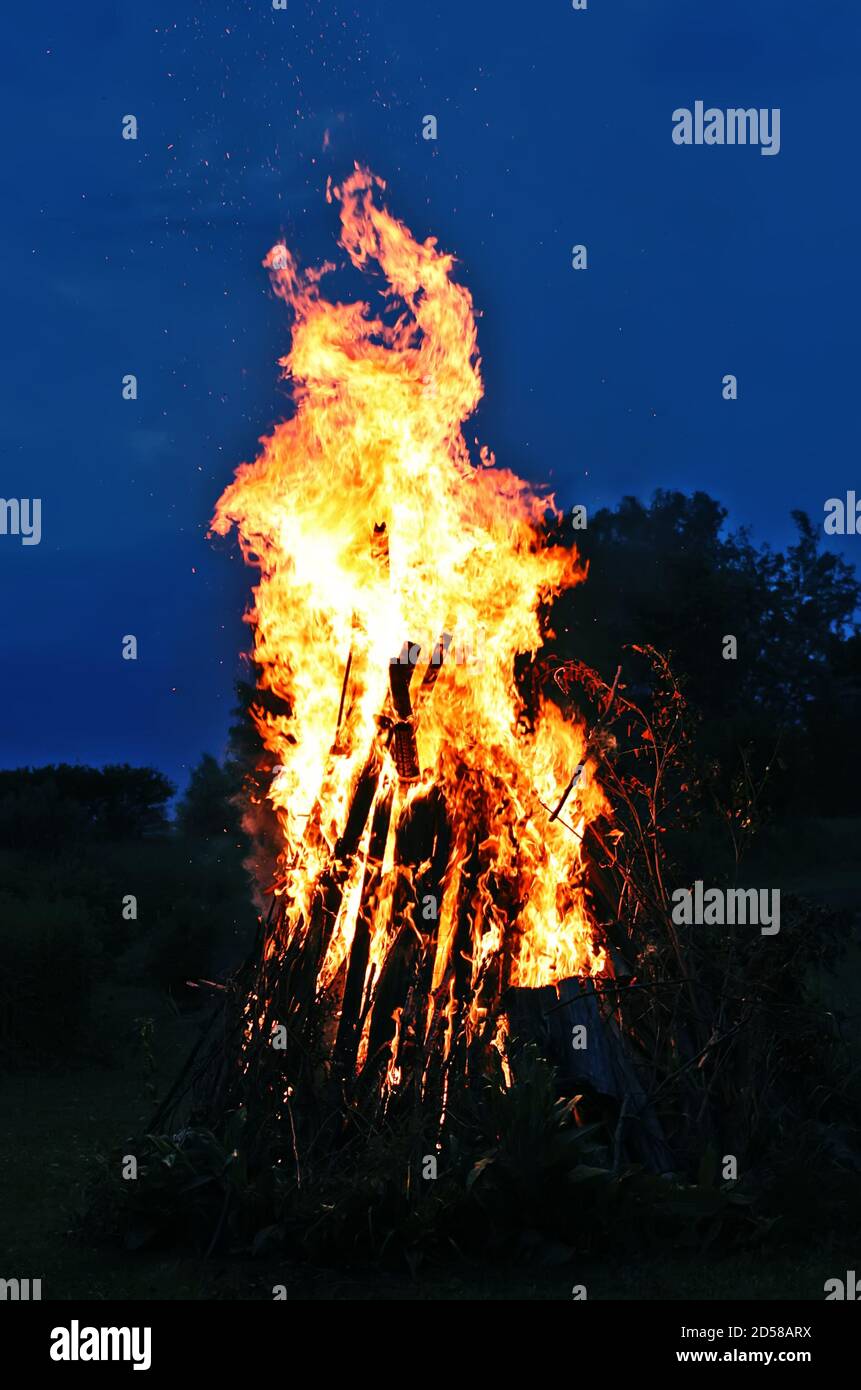 Bright bonfire flame on the rural field at summer evening Stock Photo ...
