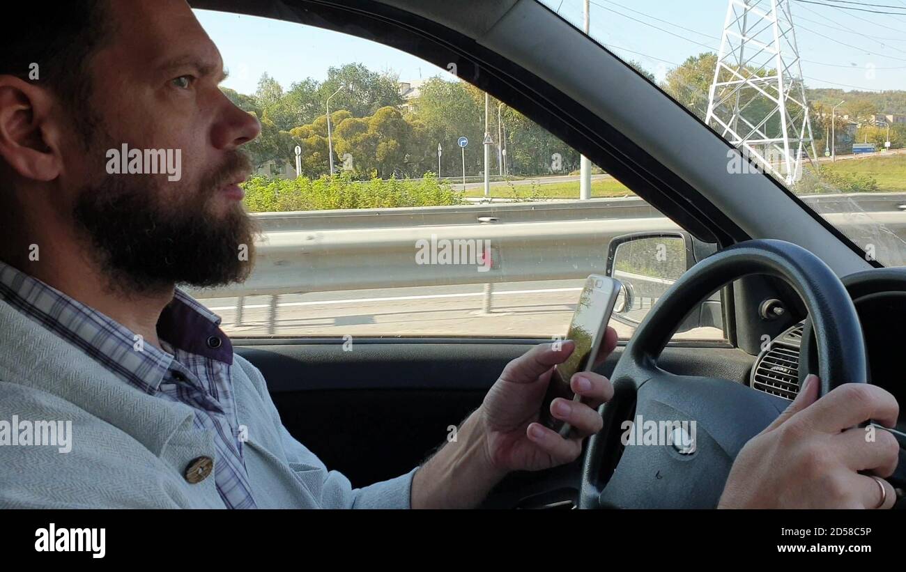 man driving with phone in hand, dangerous driving Stock Photo - Alamy