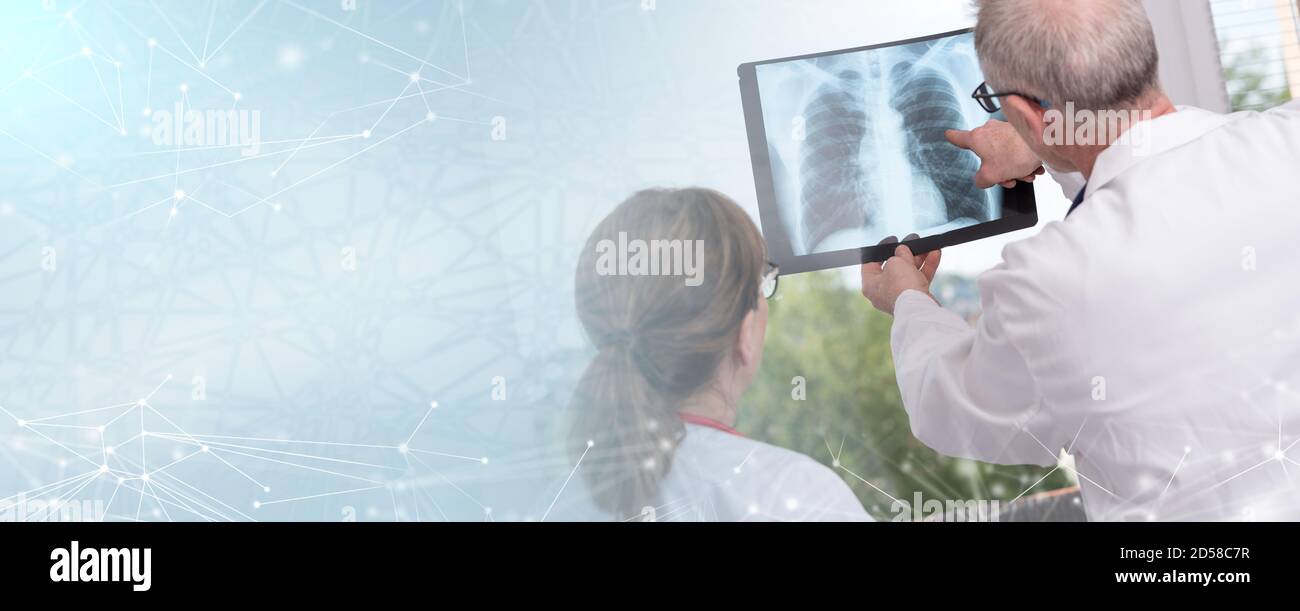 Two doctors examining x-ray report in medical office; panoramic banner ...
