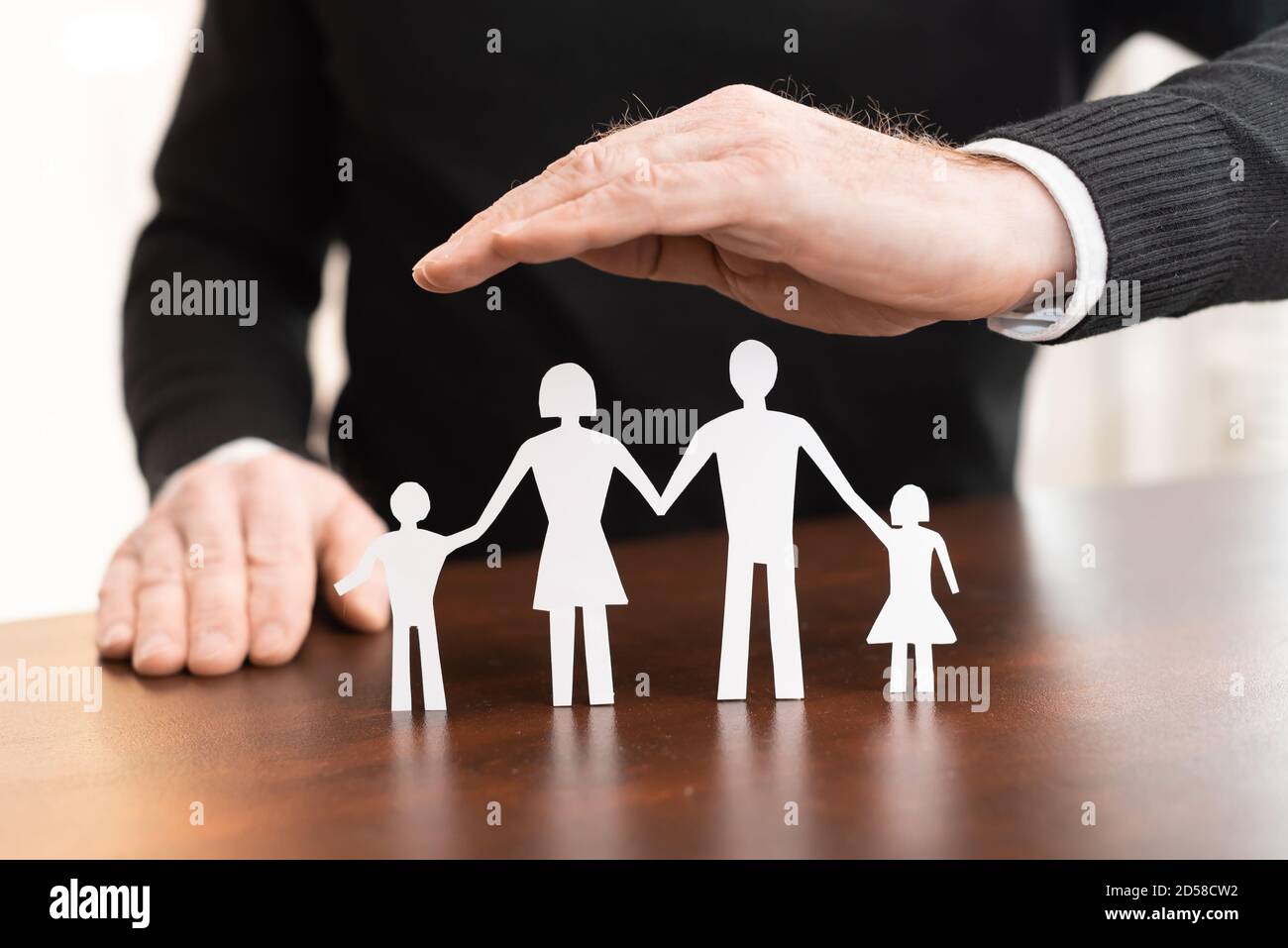 Insurer protecting a family, concept of insured family Stock Photo - Alamy