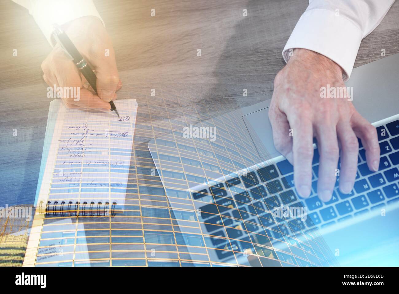 Hand of businessman taking notes while using laptop; multiple exposure ...