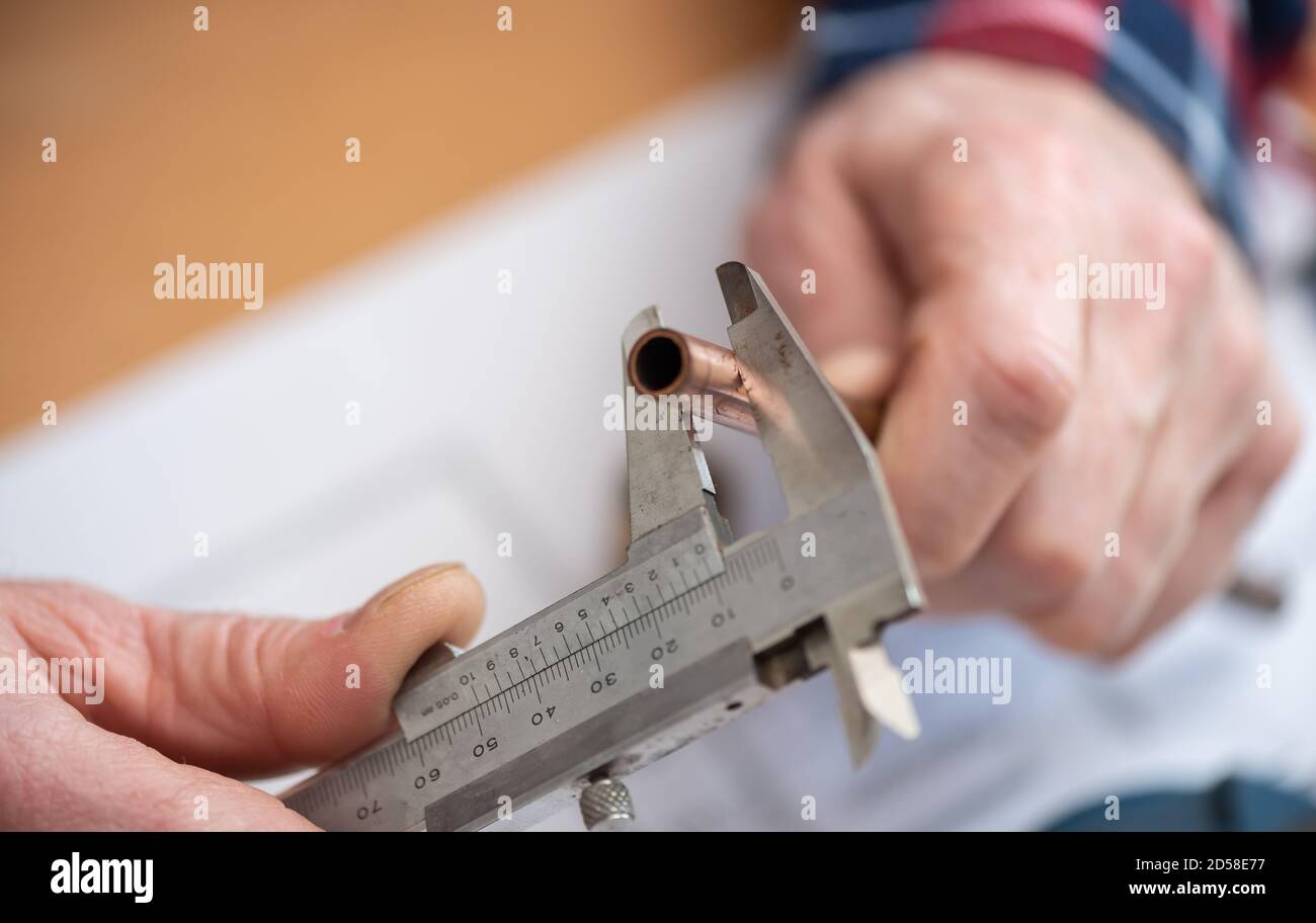 Plumber measuring a copper tube with a caliper Stock Photo - Alamy