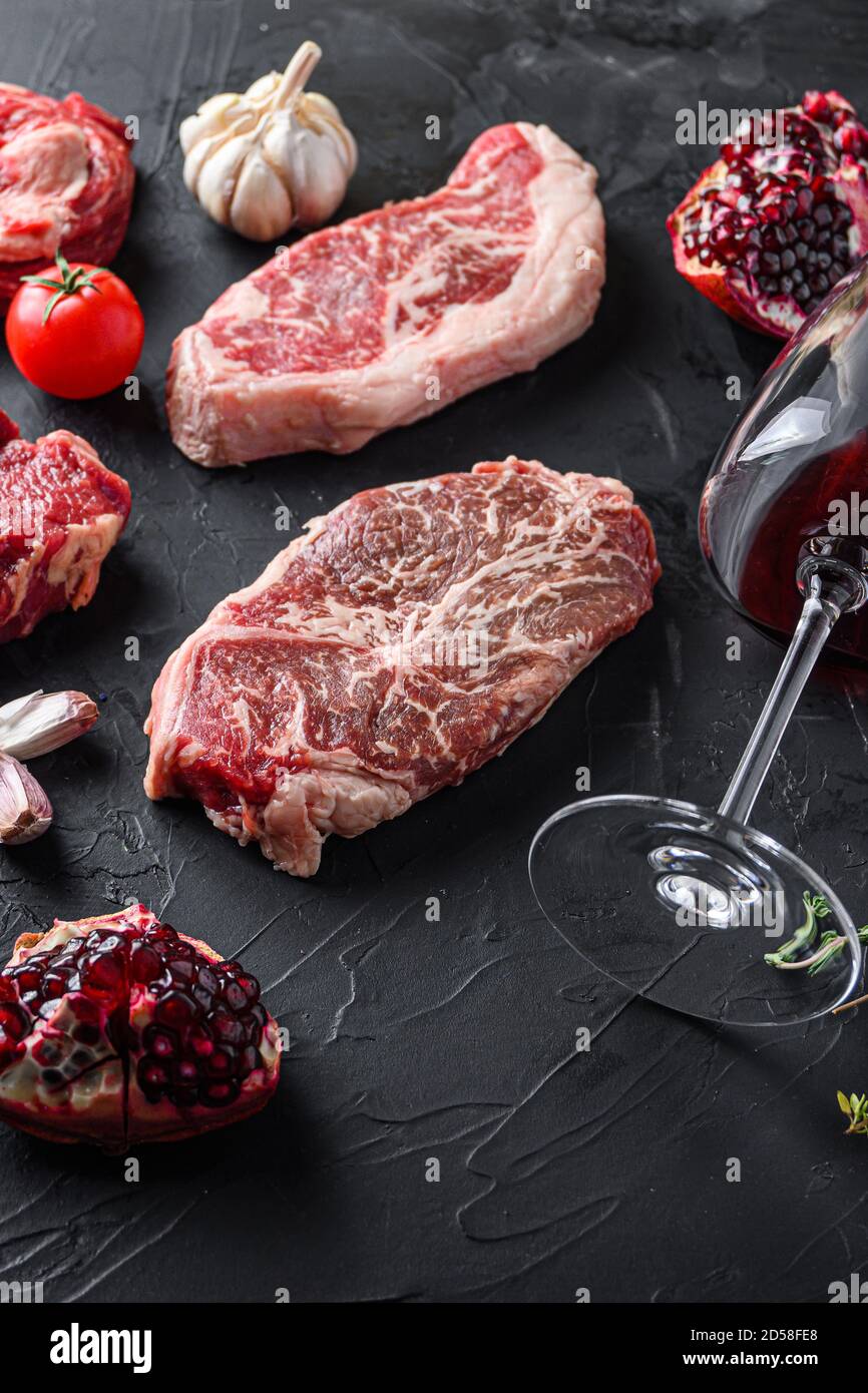 Top blade, beef steak cuts, with herbs, seasoning and red wine glass on ...
