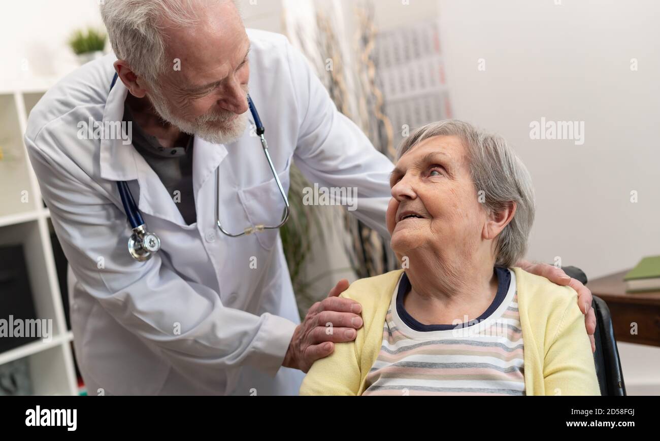 Doctor supporting elderly woman hi-res stock photography and images - Alamy