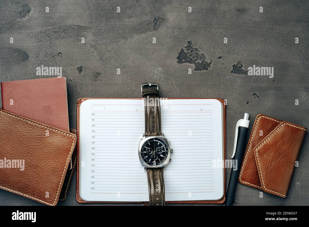 Businessman's accessories including notepad, watch and purse on dark ...