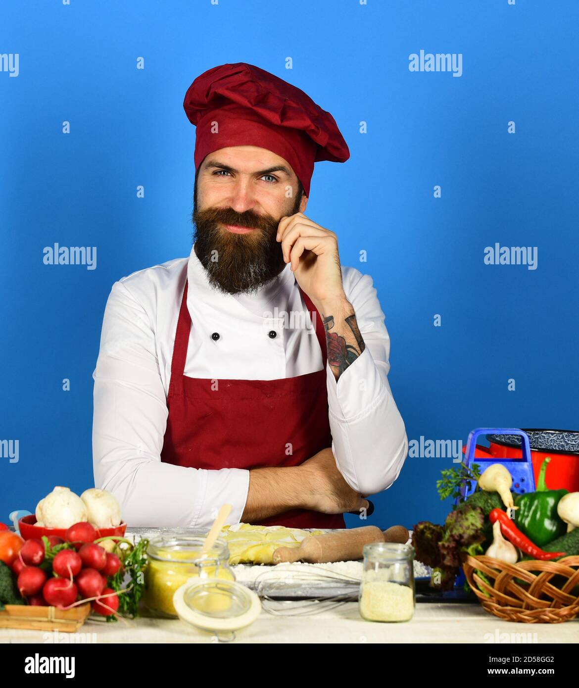 Professional cuisine concept. Cook with happy face in burgundy uniform ...