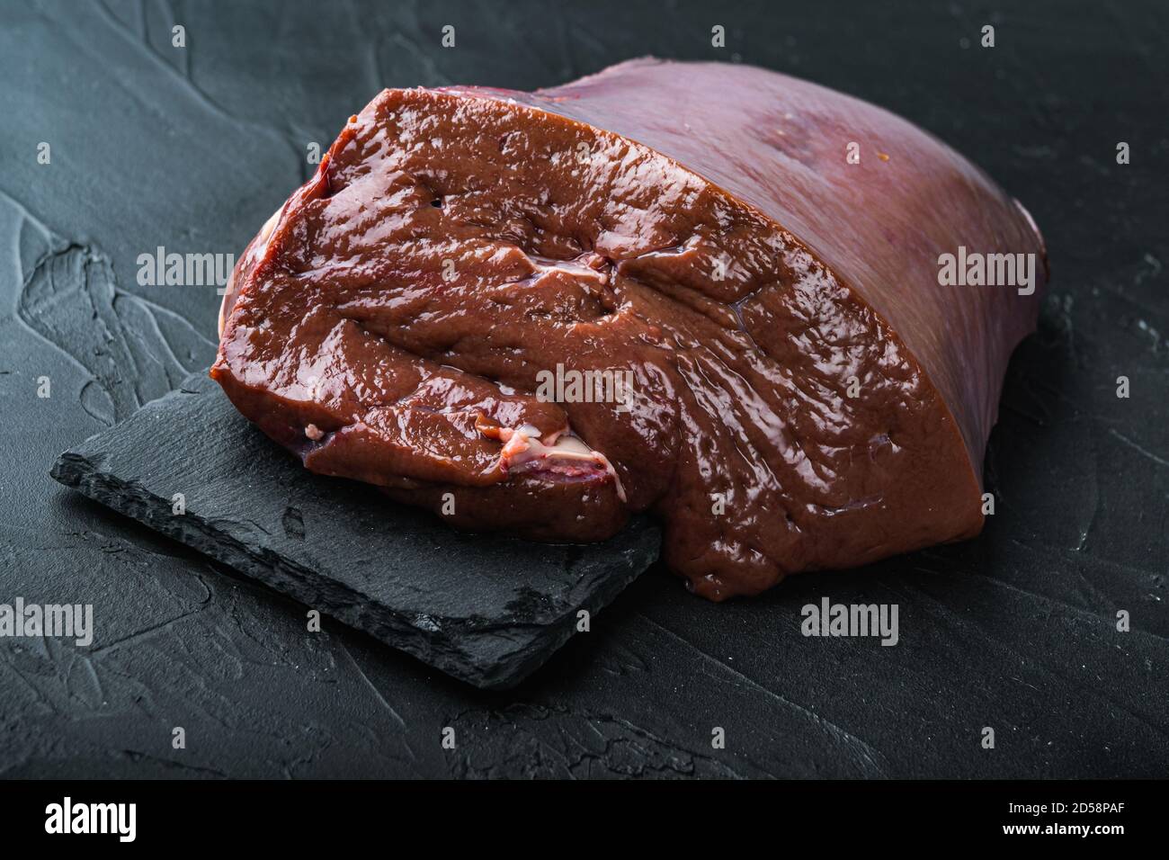 Raw liver on black background Stock Photo - Alamy
