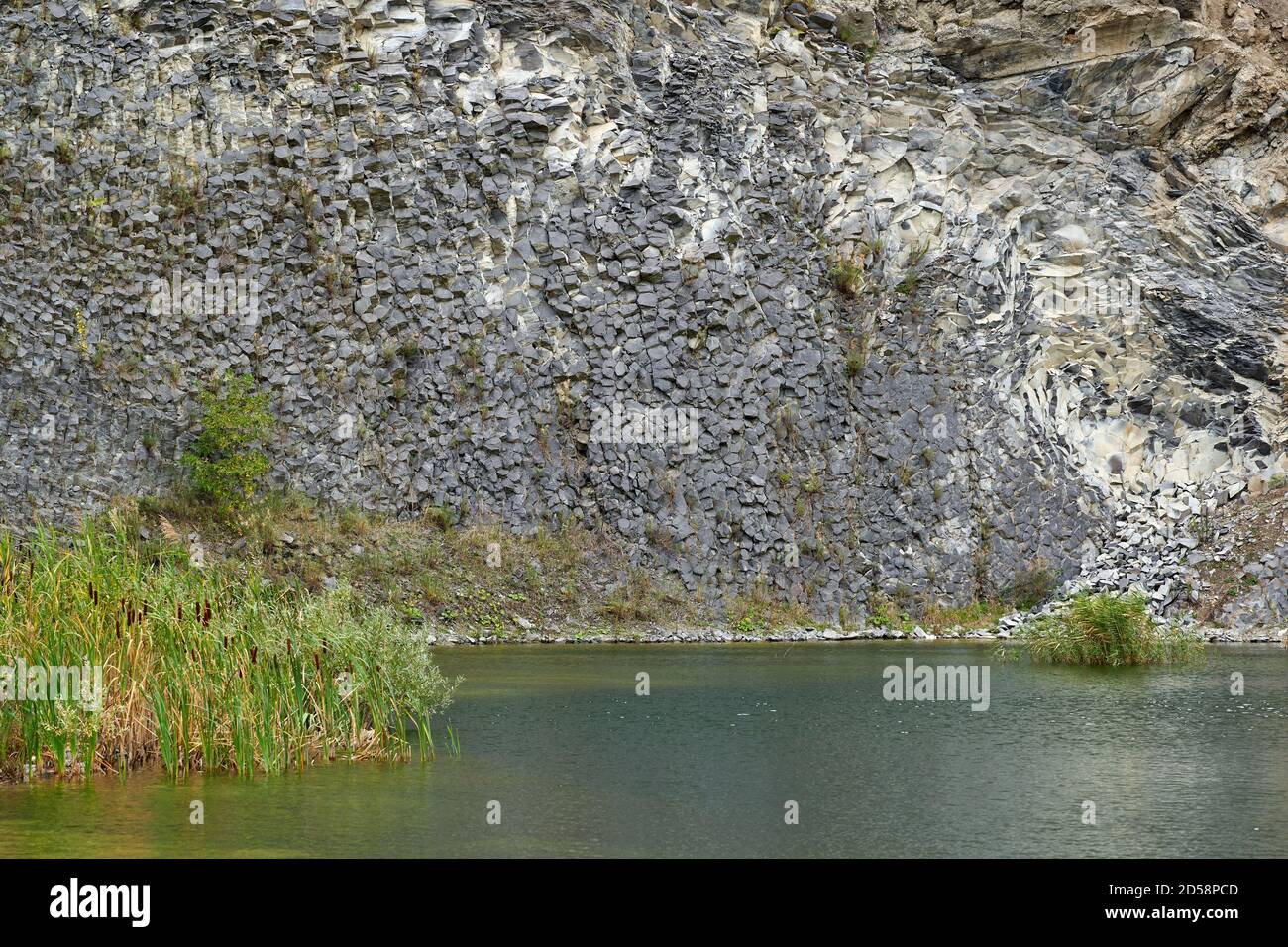 Landscape with a lake formed in an ancient quarry with sedimentary ...