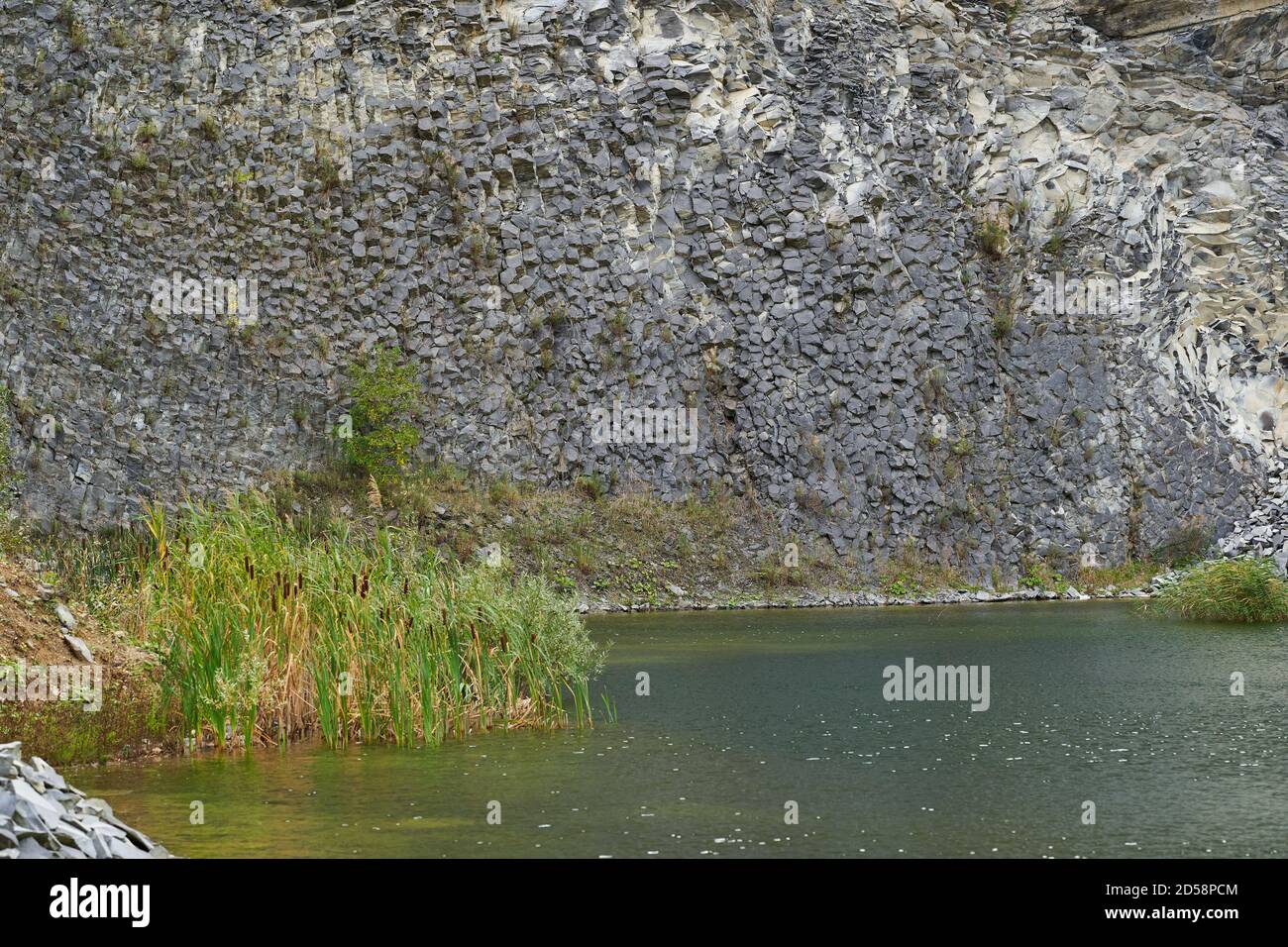 Landscape with a lake formed in an ancient quarry with sedimentary ...