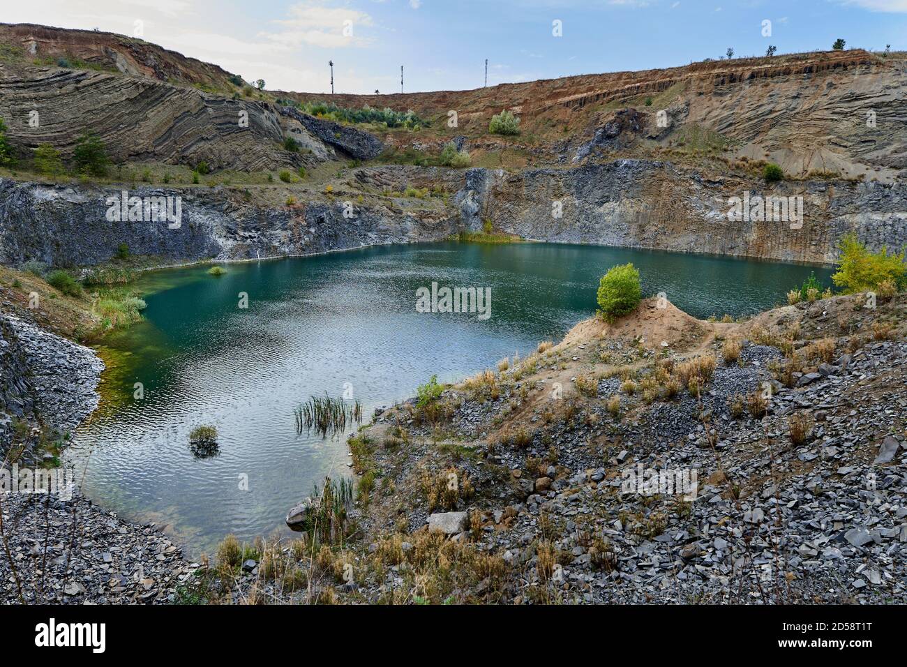 Landscape with a lake formed in an ancient quarry with sedimentary ...