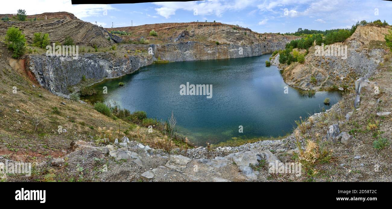 Landscape with a lake formed in an ancient quarry with sedimentary ...