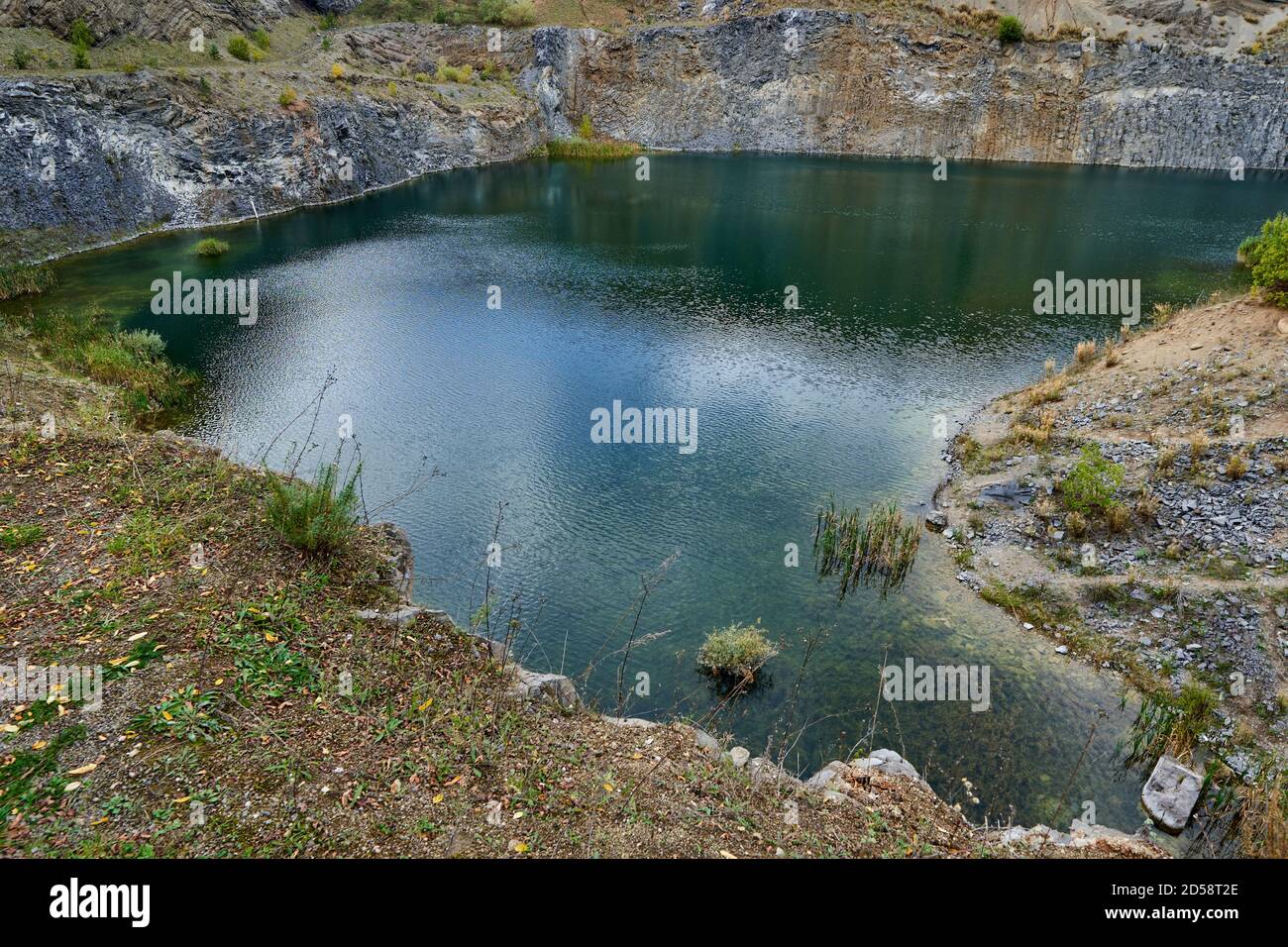 Landscape with a lake formed in an ancient quarry with sedimentary ...