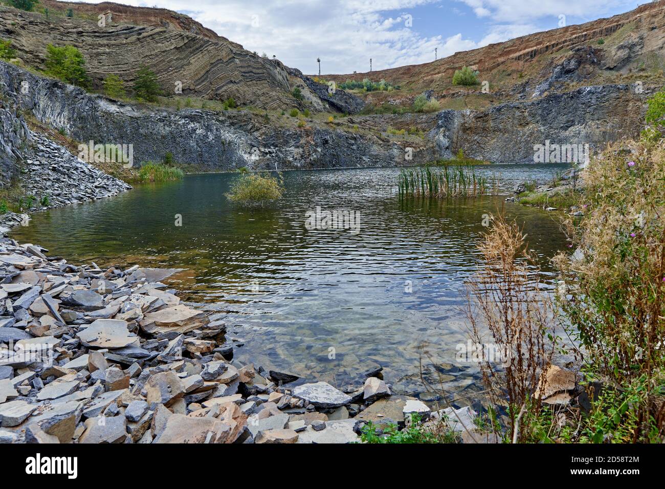 Landscape with a lake formed in an ancient quarry with sedimentary ...