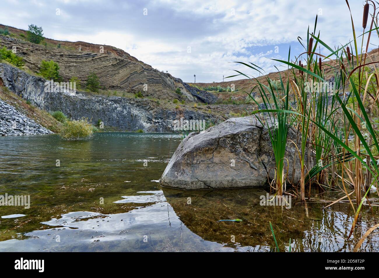 Landscape with a lake formed in an ancient quarry with sedimentary ...
