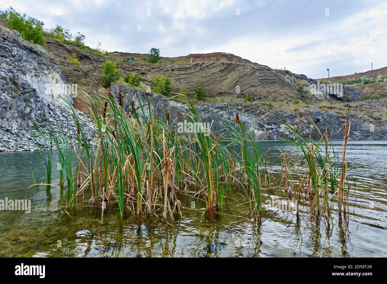 Landscape with a lake formed in an ancient quarry with sedimentary ...