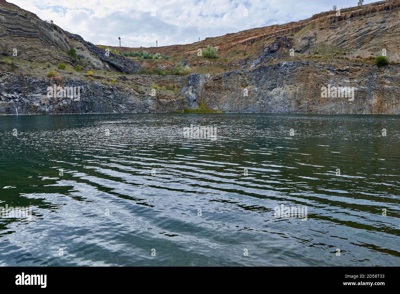 Landscape with a lake formed in an ancient quarry with sedimentary ...