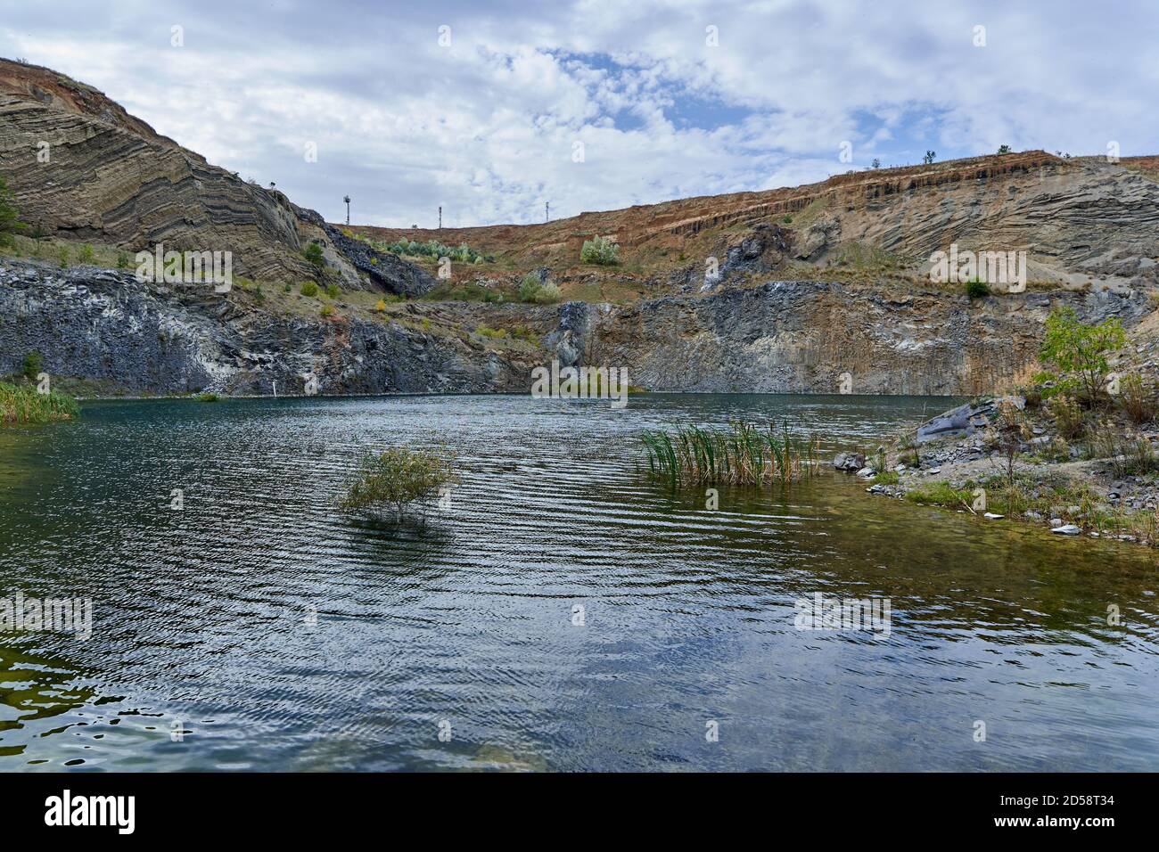 Landscape with a lake formed in an ancient quarry with sedimentary ...