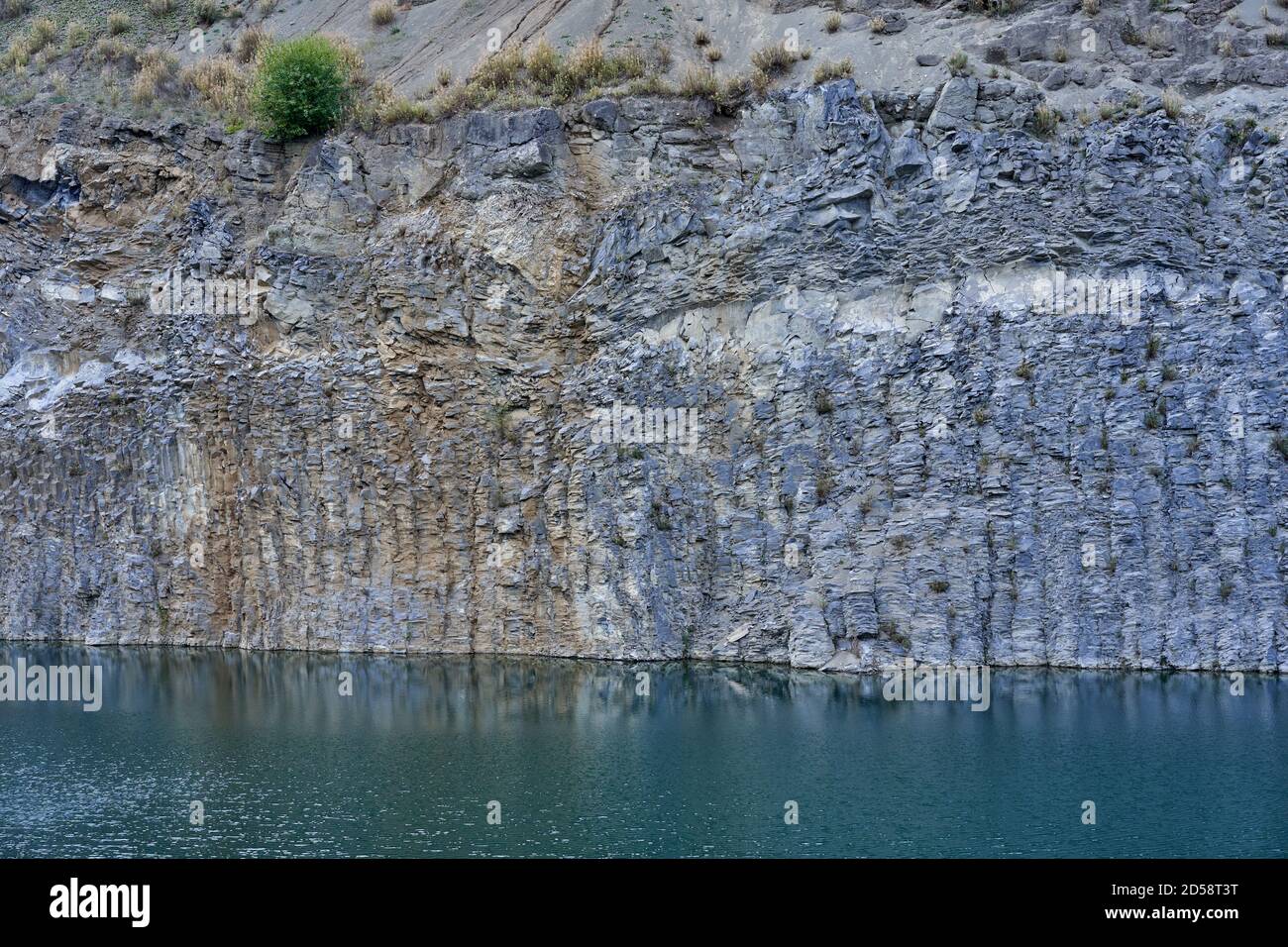 Landscape with a lake formed in an ancient quarry with sedimentary ...