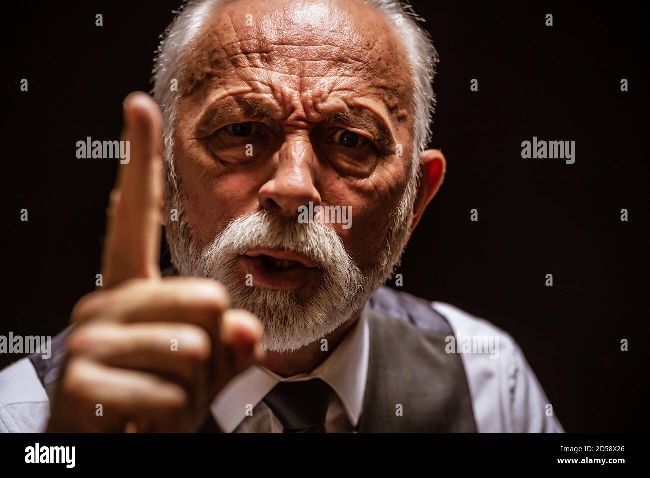 Portrait of angry senior man who threatens. Black background Stock ...