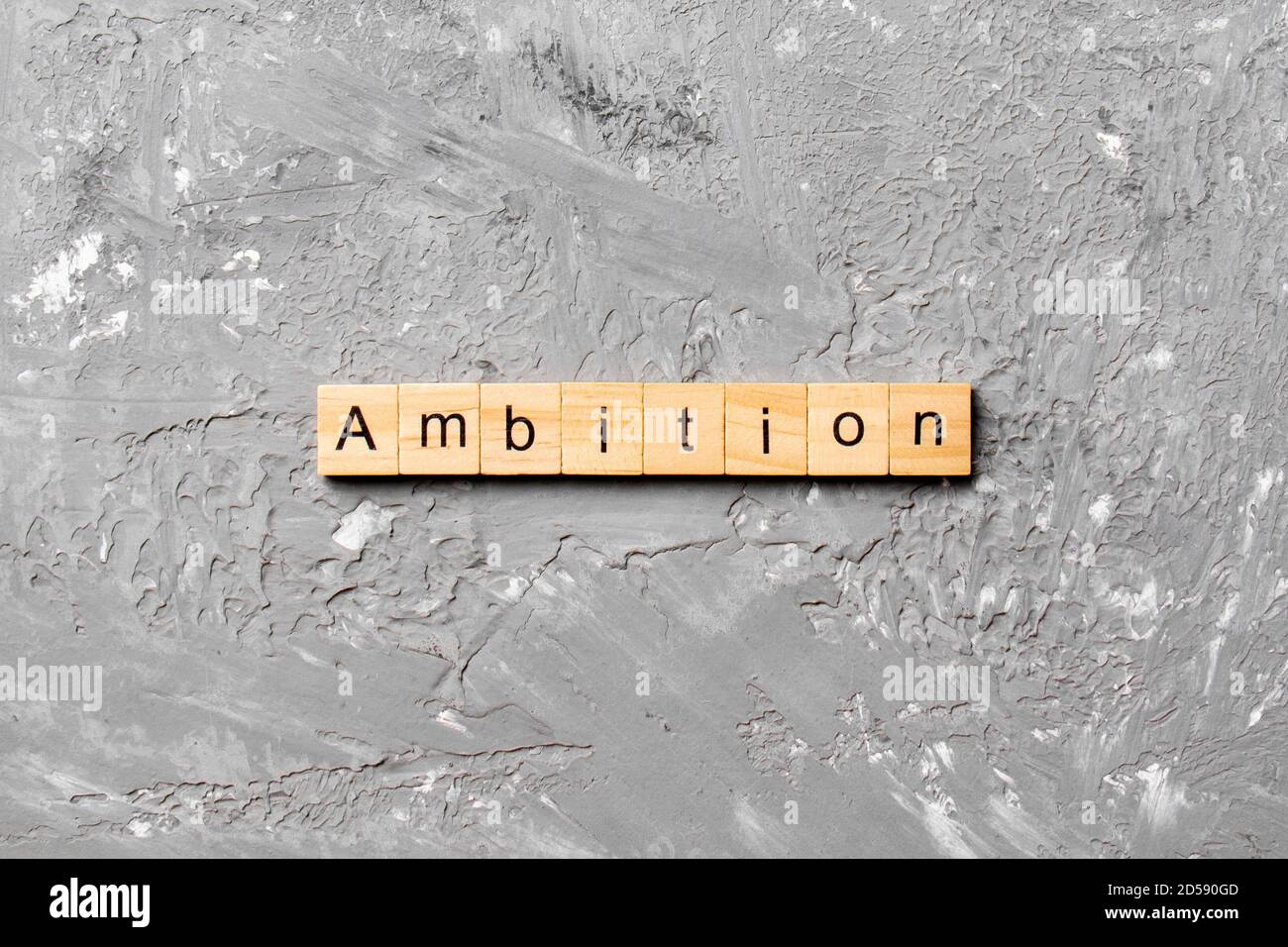 ambition word written on wood block. ambition text on cement table for ...