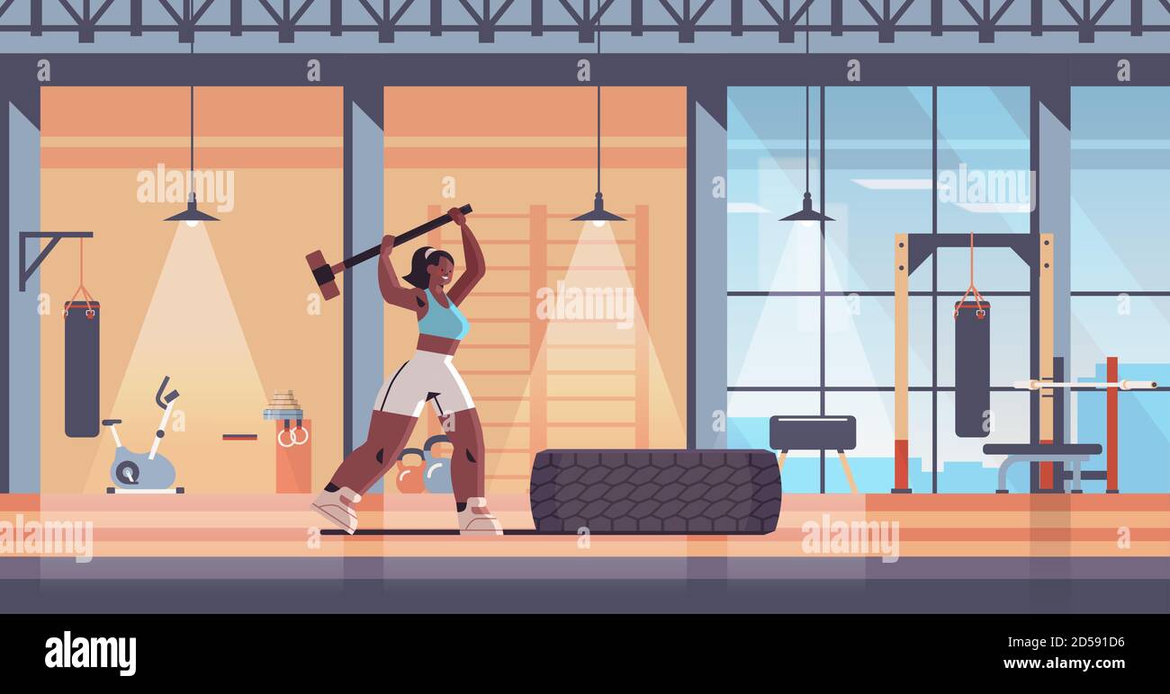 sportswoman hitting tire with hummer girl doing hard exercises working ...