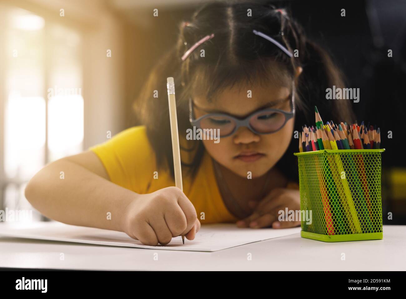 Asian girl with Down's syndrome drawing picture in art class. Concept ...