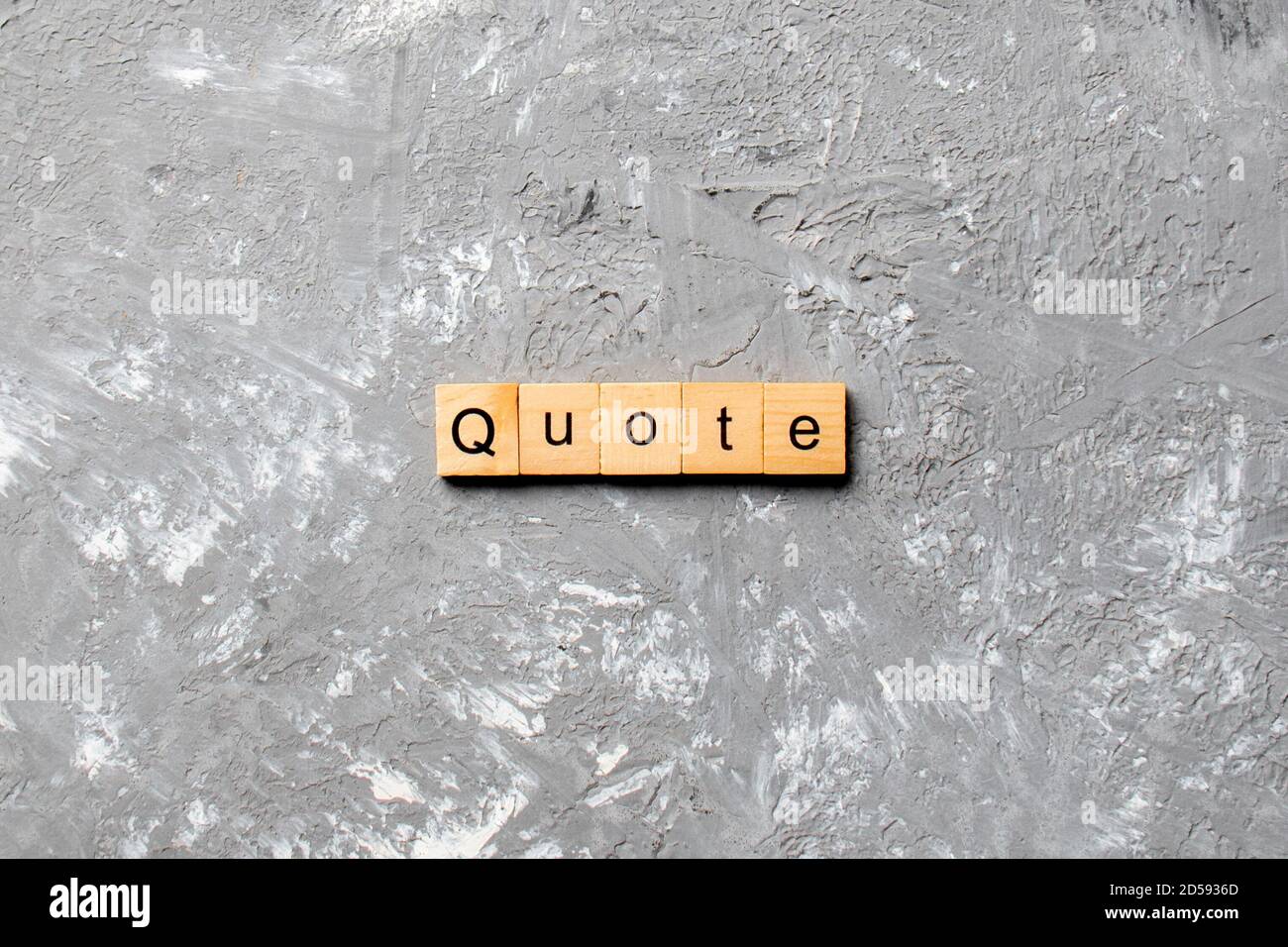 Quote word written on wood block. Quote text on cement table for your ...
