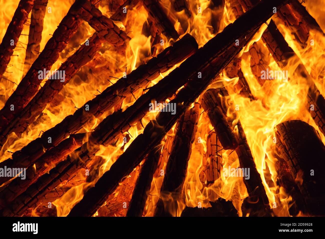 Bright bonfire flame outdoors. Firewood and wooden sticks burning in ...