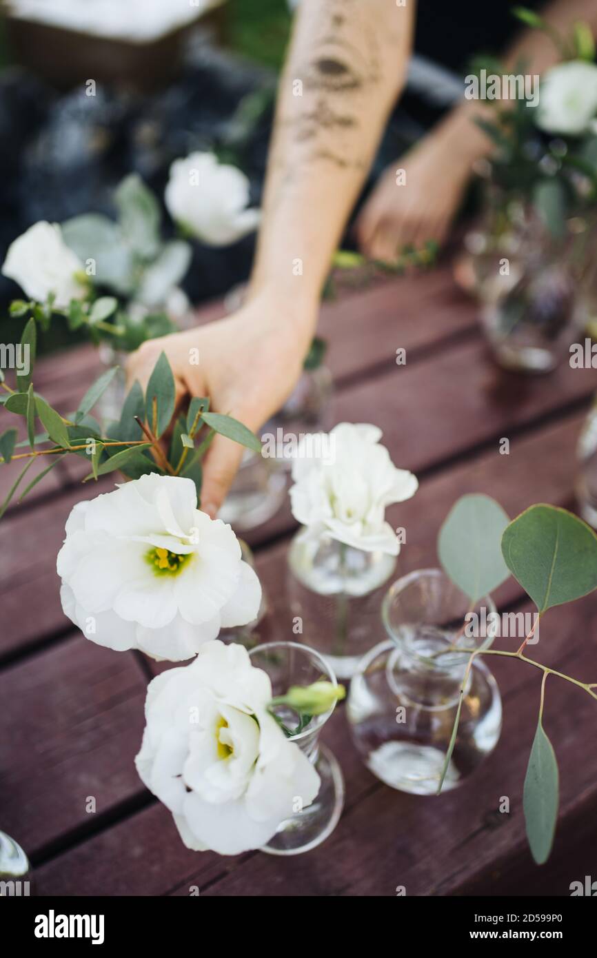 Woman putting flowers in vases Stock Photo - Alamy