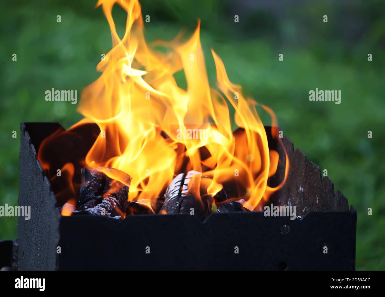 Bright flame of a burning fire above the brazier outdoors Stock Photo ...