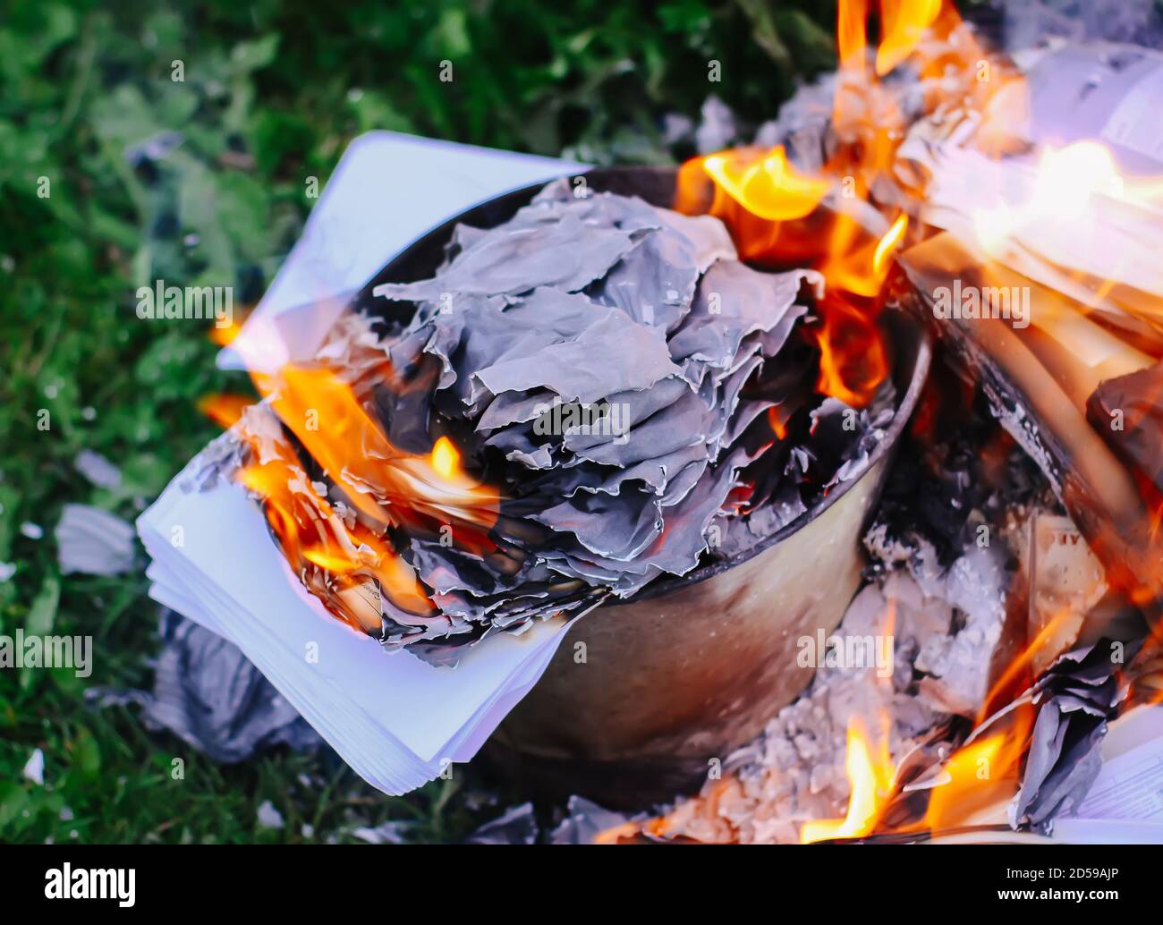 Paper burning on green summer grass outdoors Stock Photo - Alamy