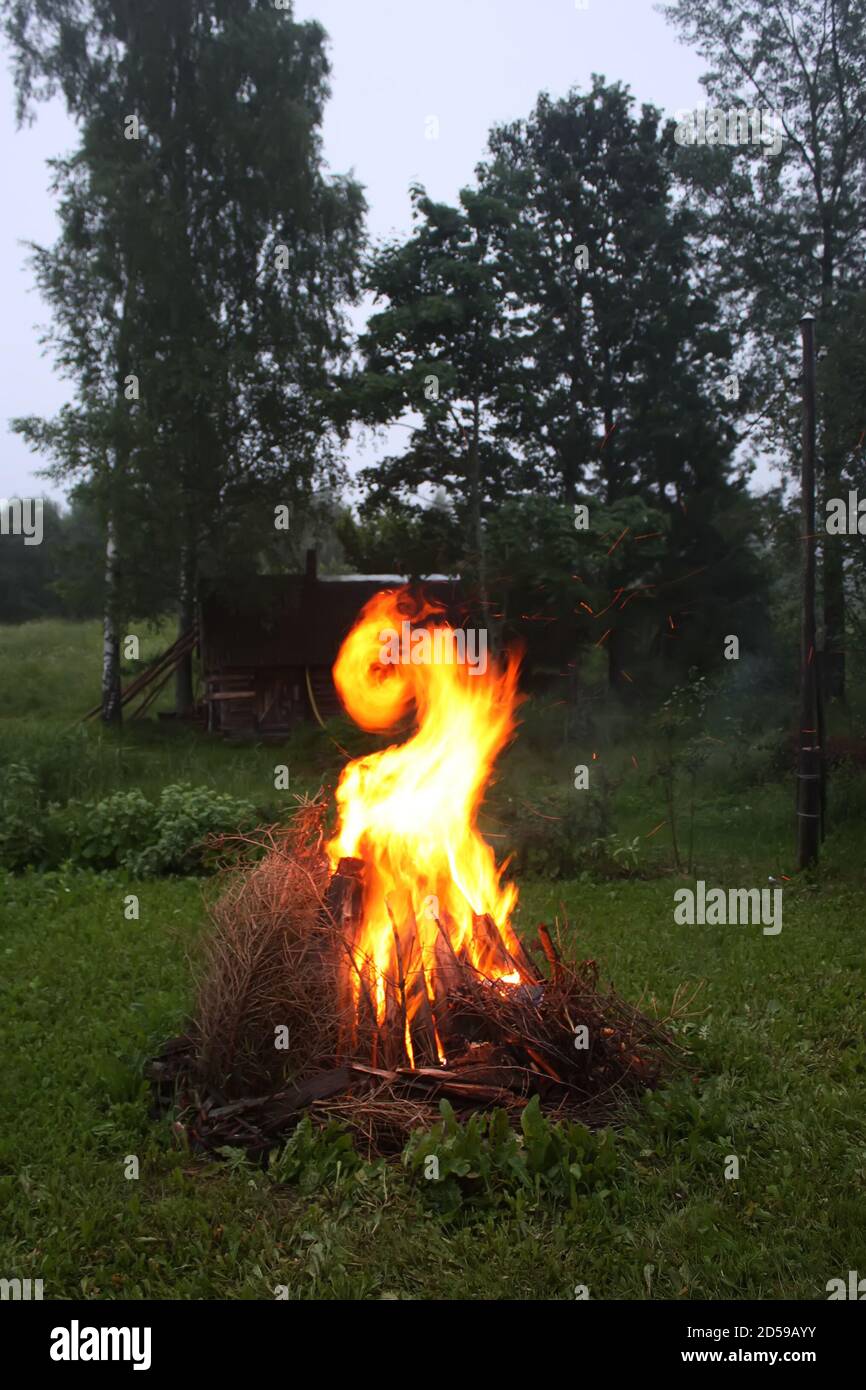 Bright bonfire flame on the rural field at evening Stock Photo - Alamy