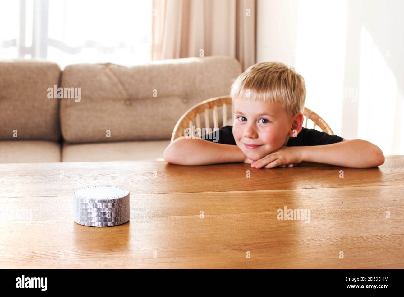 Cute boy sitting and listening to the smart speaker Stock Photo - Alamy