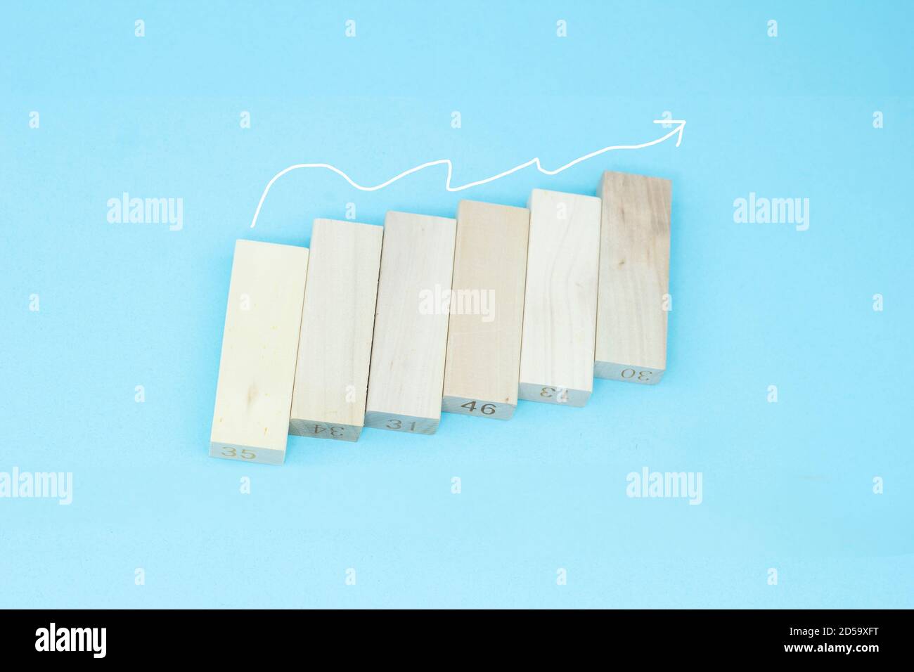 Wooden block stacking as step stair with white arrow up on blue ...