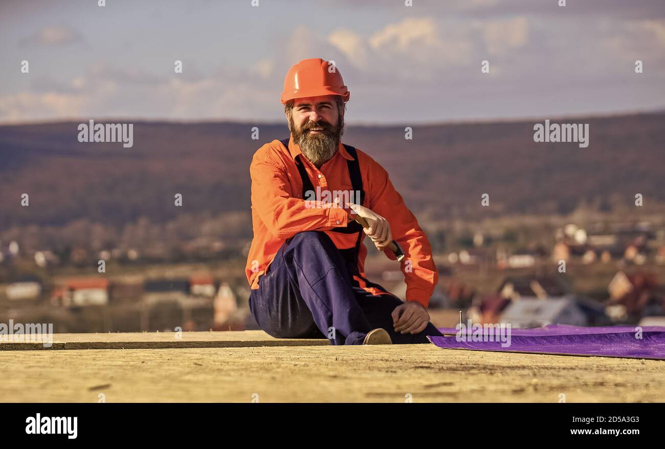 in work clothes. roofer working on roof structure of building on ...