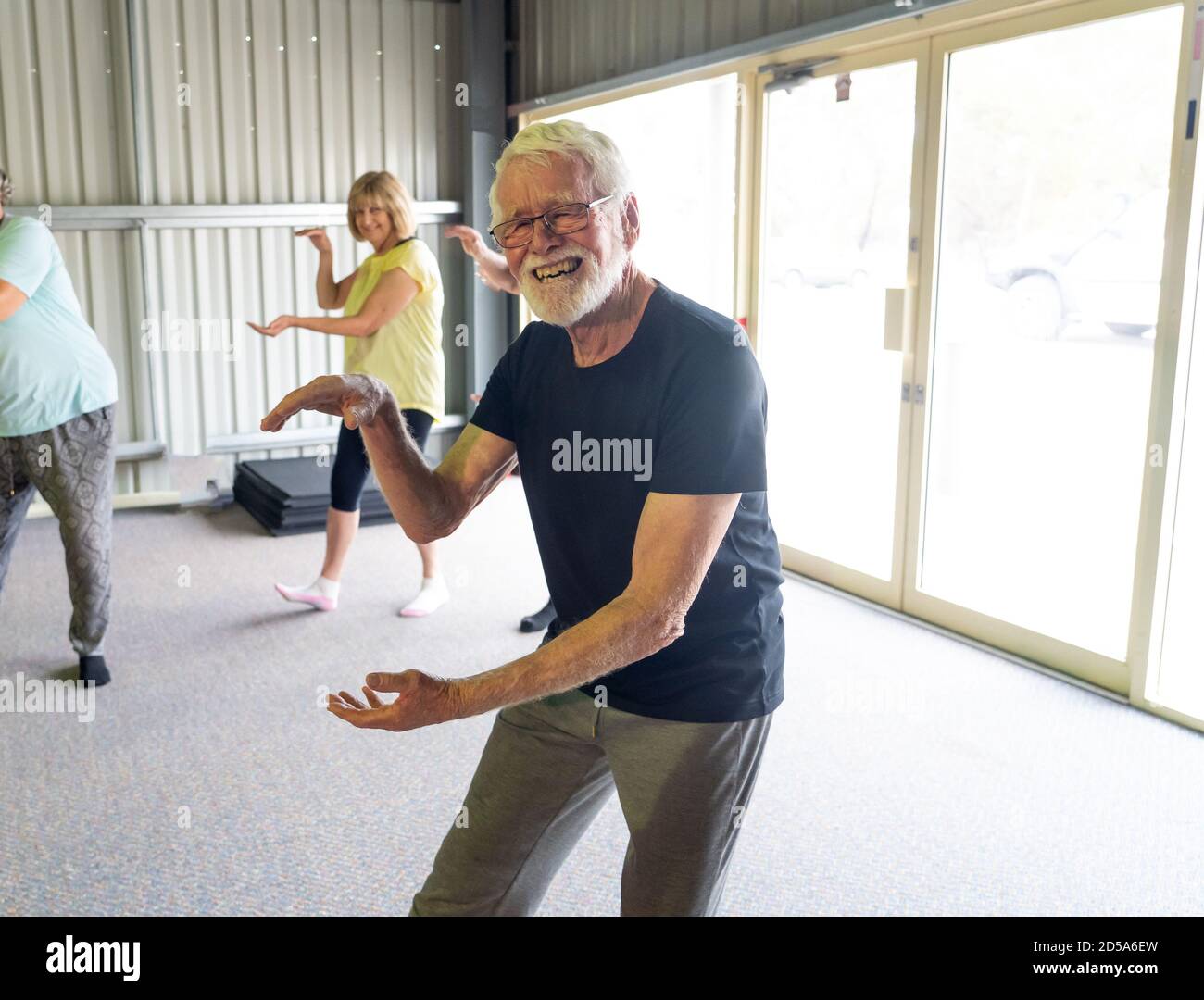 Group of seniors in Tai Chi class exercising in an active retirement ...