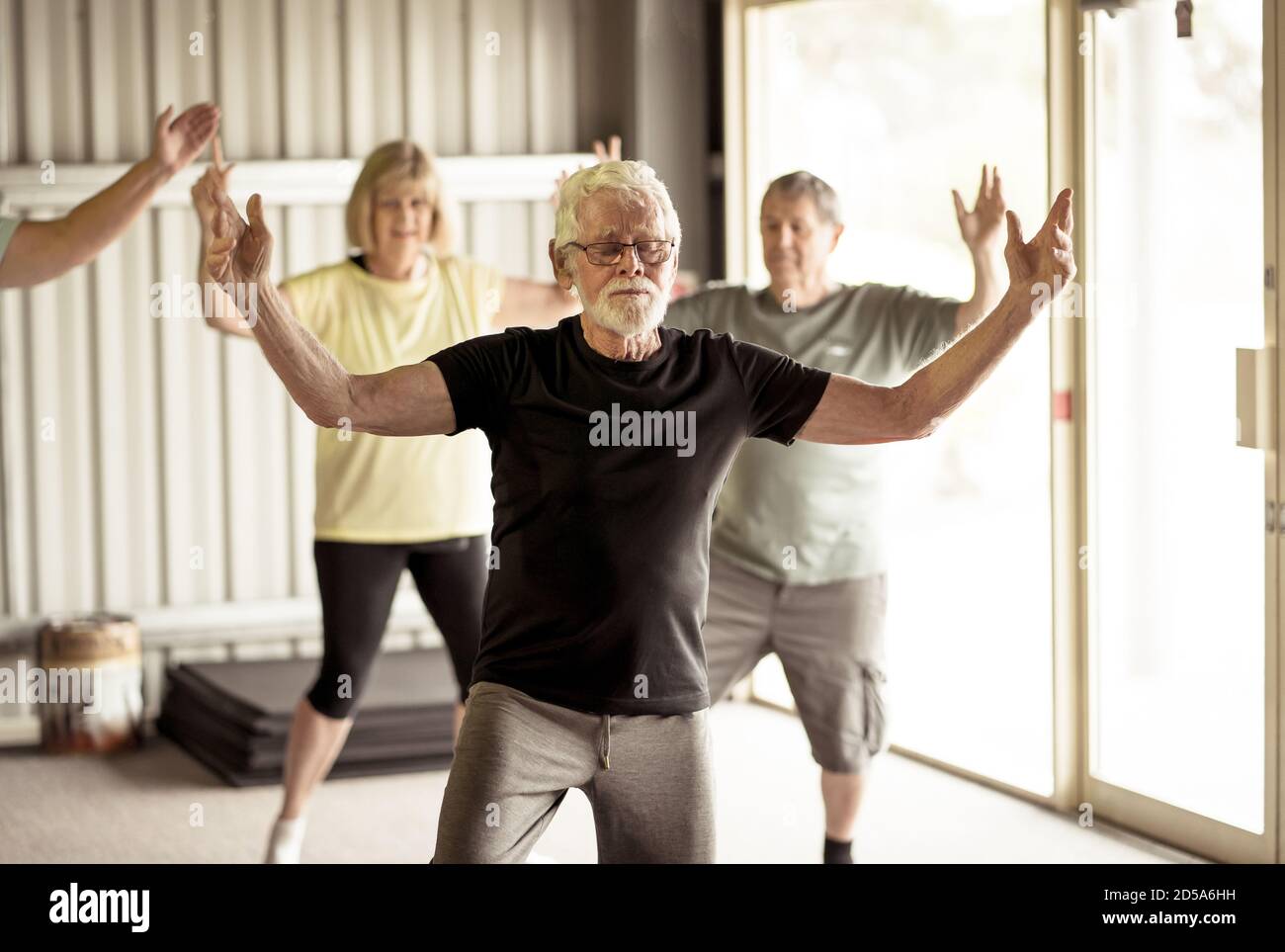 Group of seniors in Tai Chi class exercising in an active retirement ...