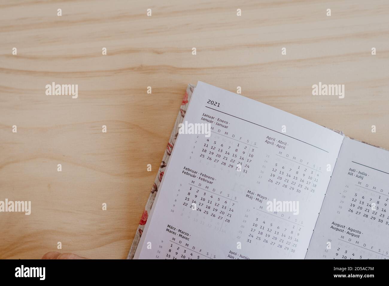 an open planner in the 2021 calendar, is on top of a wooden desk Stock ...