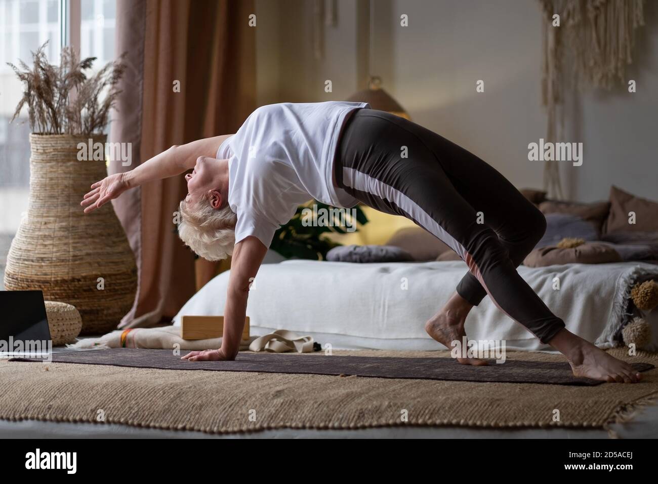 Senior woman doing standing mermaid stretch training at home Stock ...