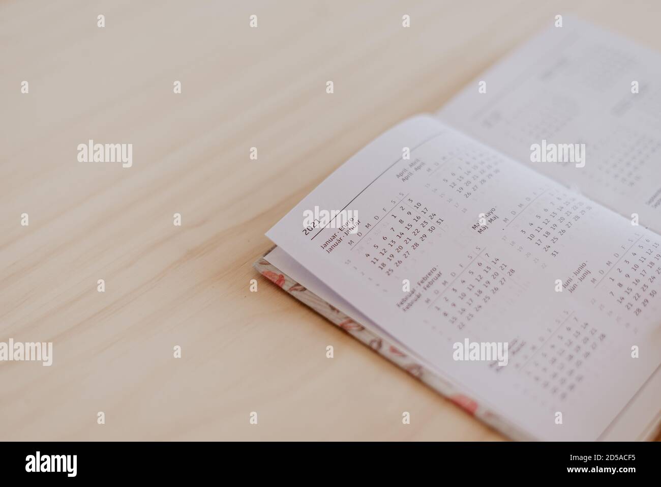 an open planner in the 2021 calendar, is on top of a wooden desk Stock ...