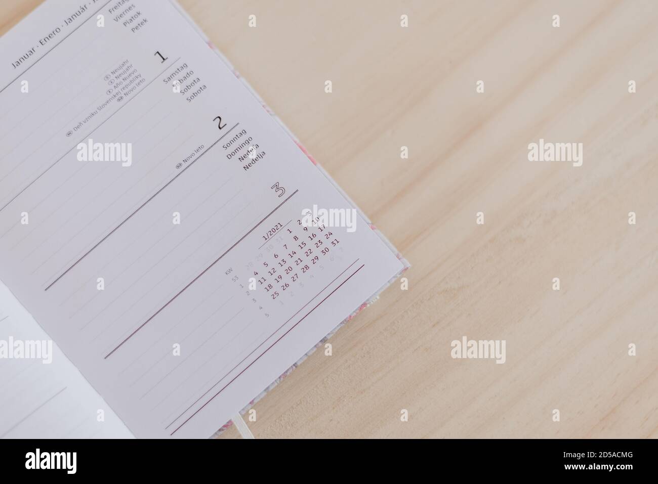 an open planner in the 2021 calendar, is on top of a wooden desk Stock ...