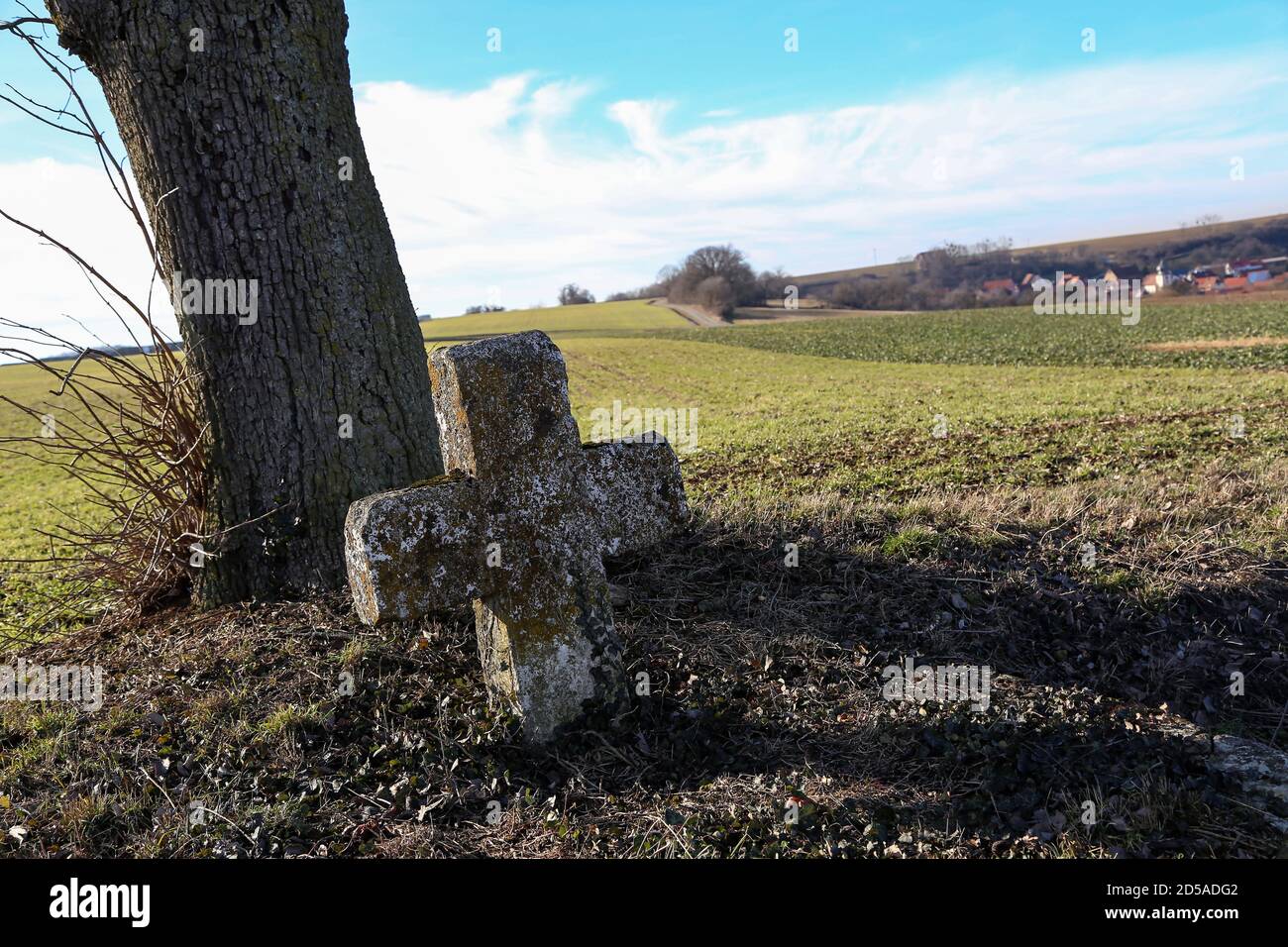 Ancient stone cross under a tree by the road Stock Photo - Alamy