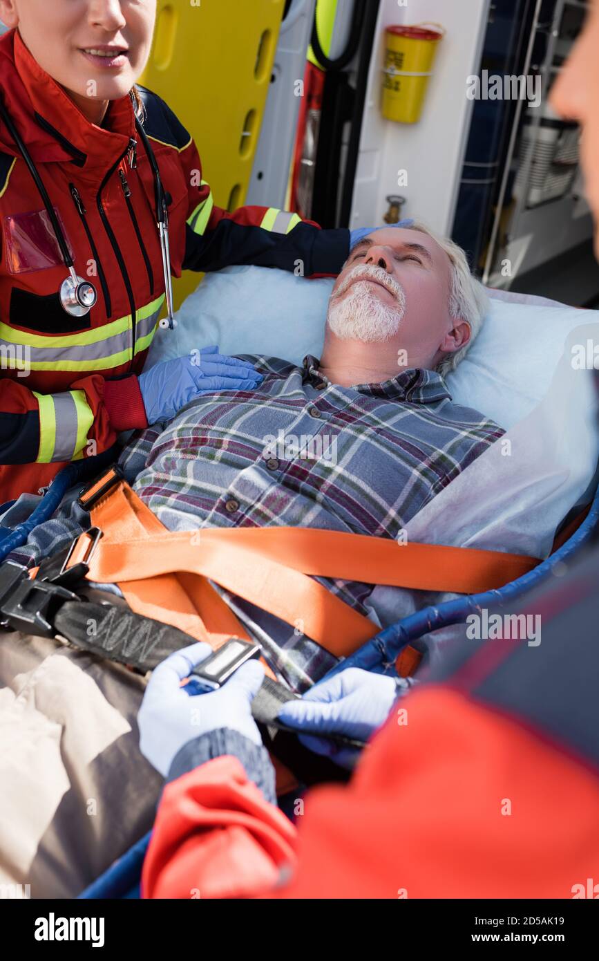 Selective focus of paramedic standing near patient while colleague ...