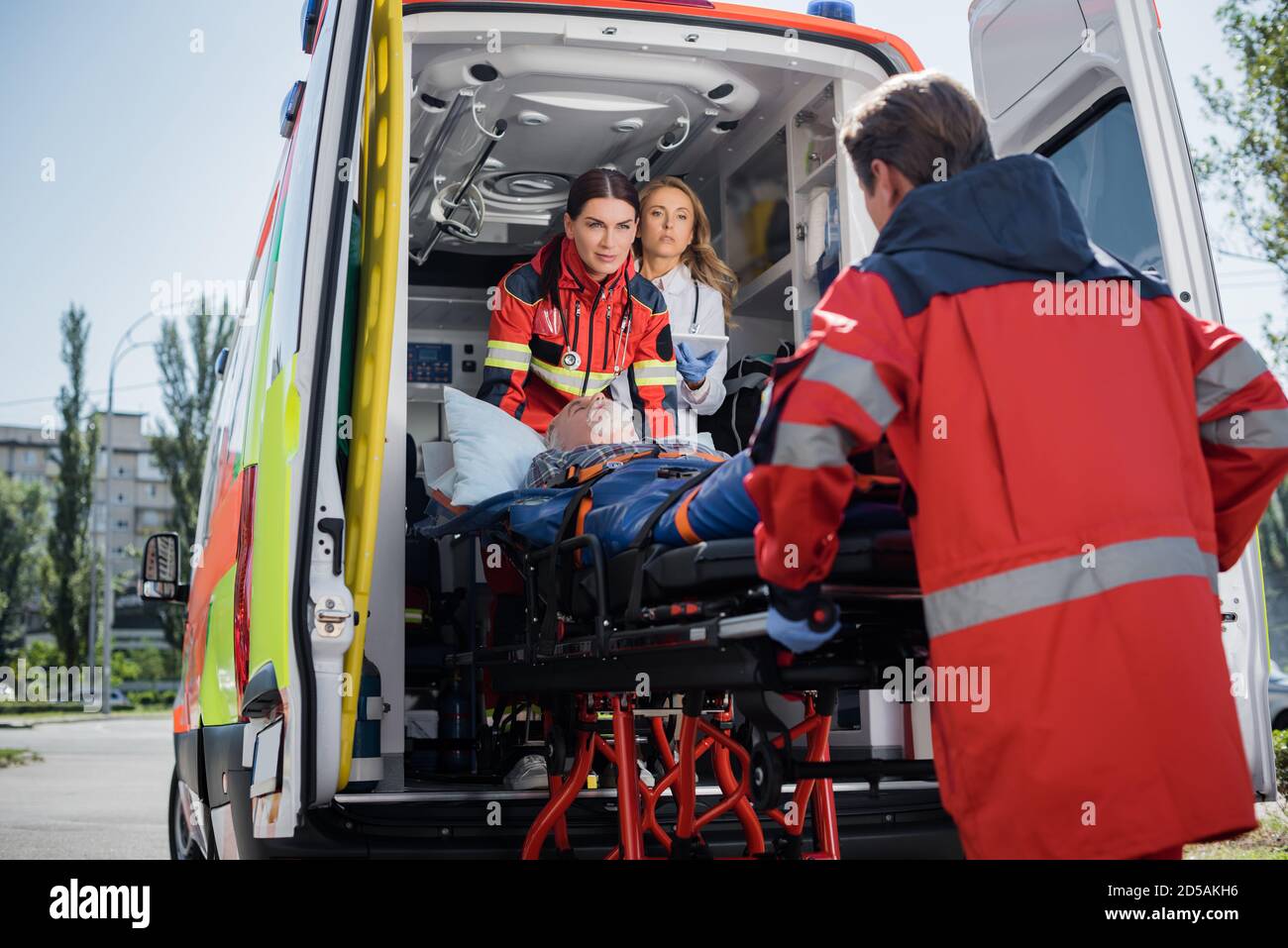 Selective focus of doctor with digital tablet standing in ambulance car ...