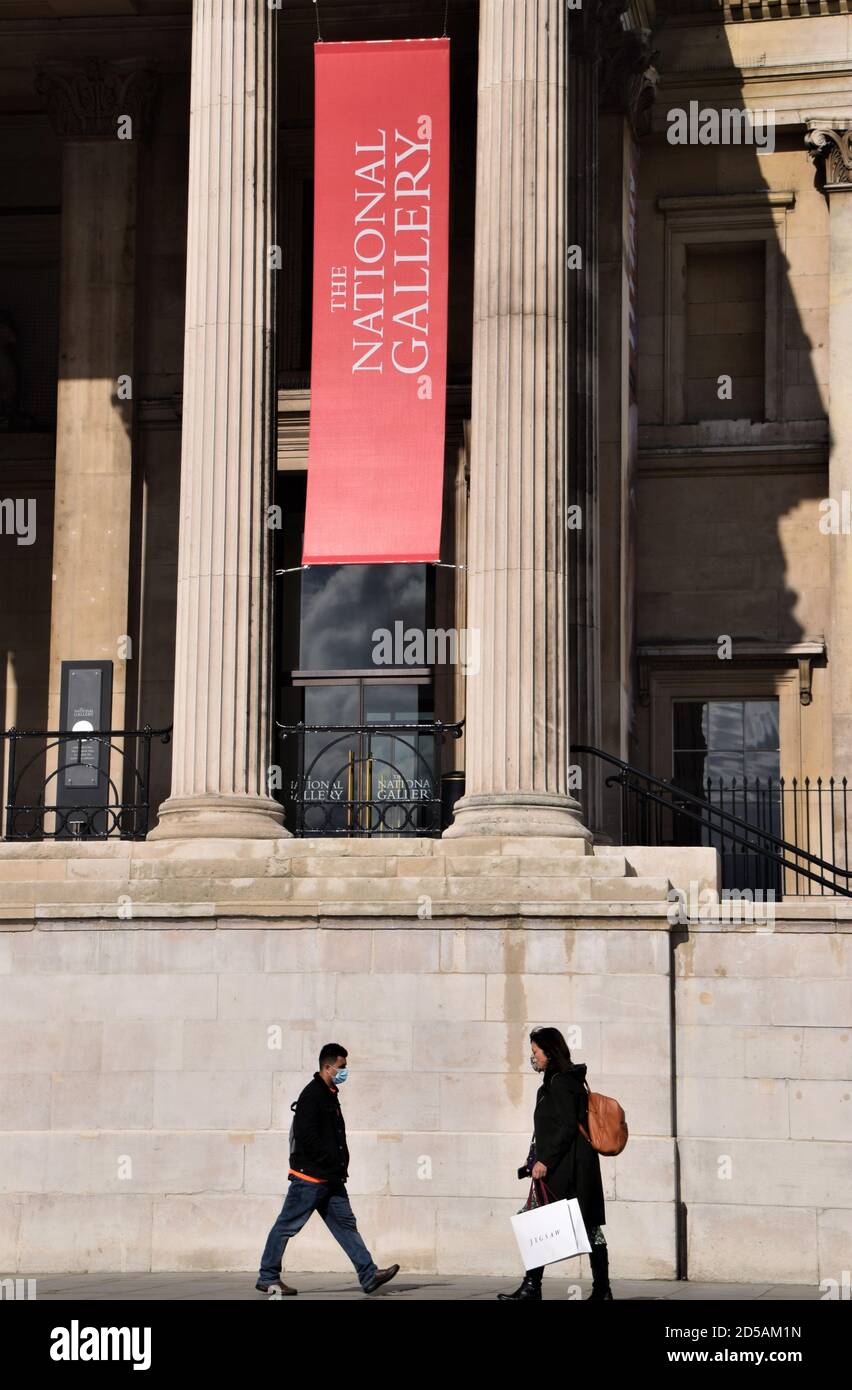 People wearing protective face masks walk past The National Gallery on ...