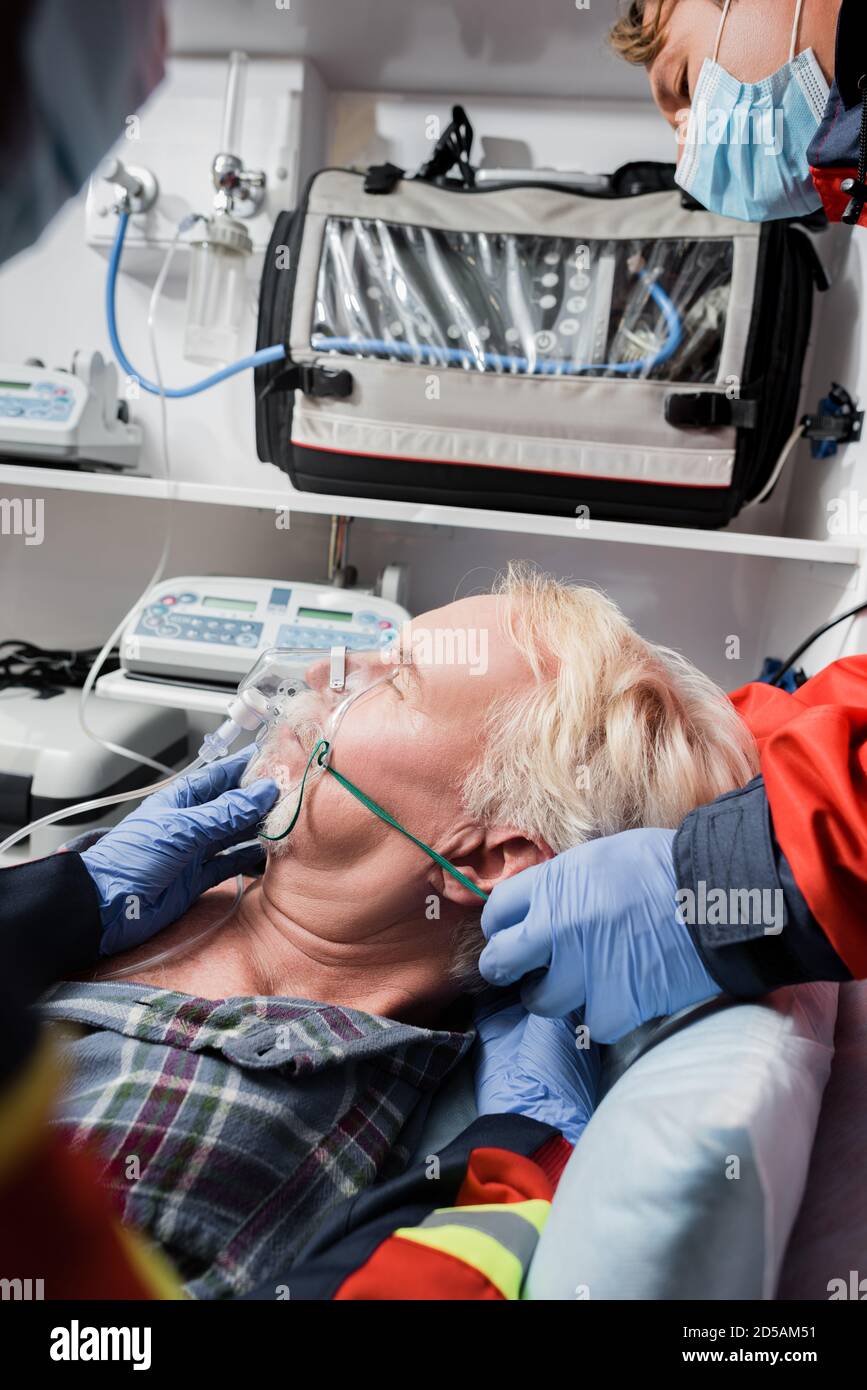 Selective focus of paramedics in medical masks and latex gloves wearing ...