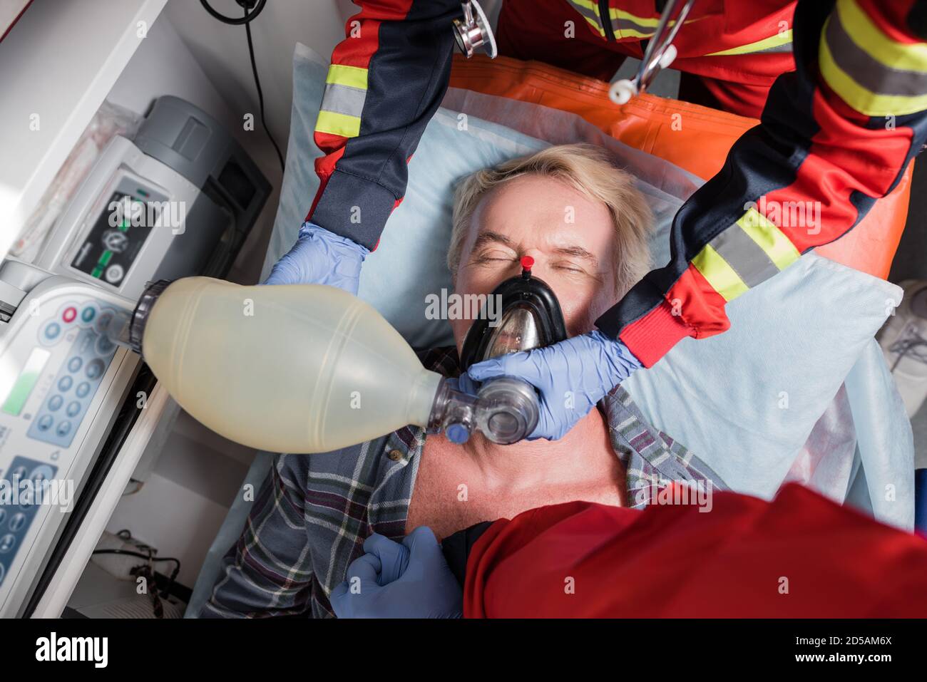 Top view of paramedics in latex gloves doing cardiopulmonary resuscitation to senior man Stock ...